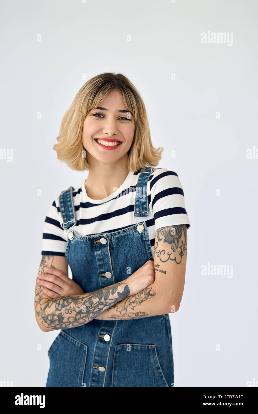 Happy gen z blonde young woman with tattoos standing isolated on white ...