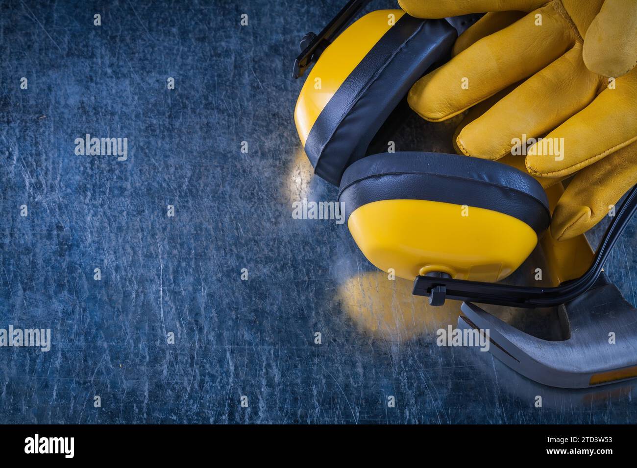 Soundproofing headphones Claw hammer and protective gloves on metallic ...