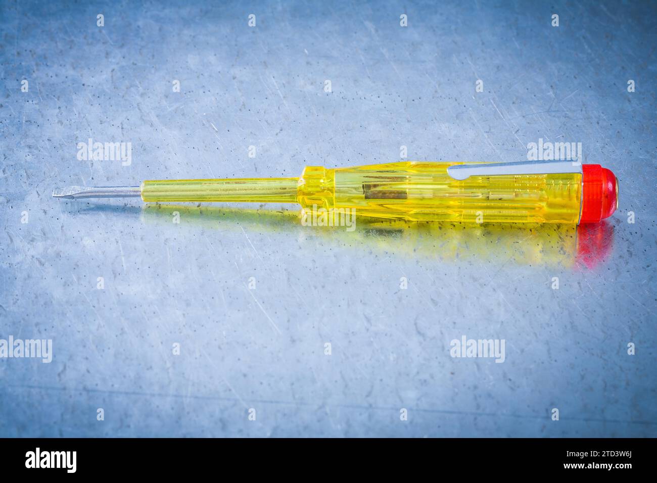 Insulated electric screwdriver tester on scratched metallic background ...