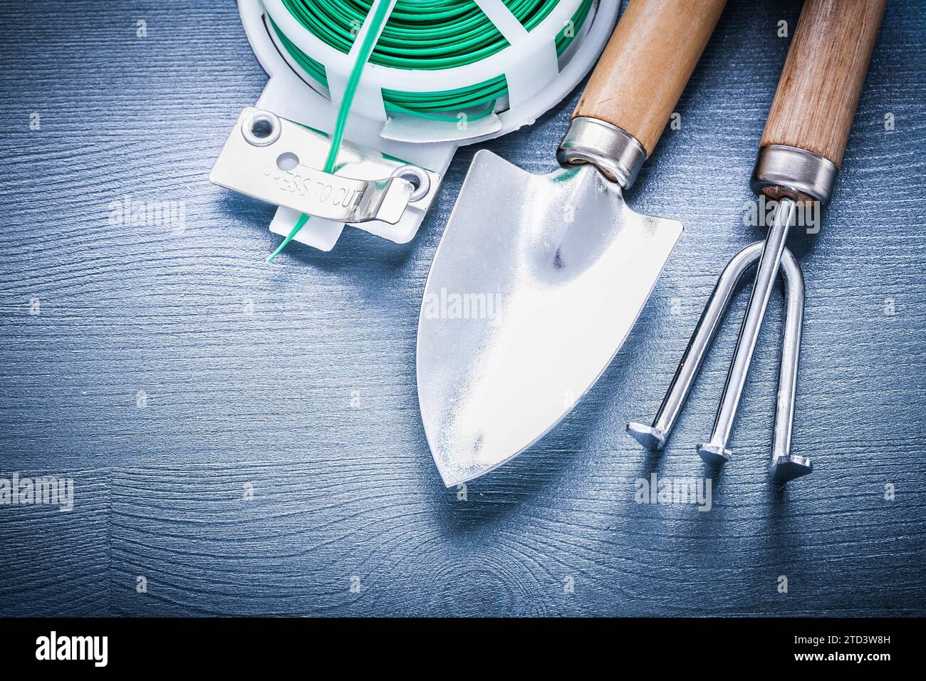 Fork spade and green garden wire Stock Photo - Alamy