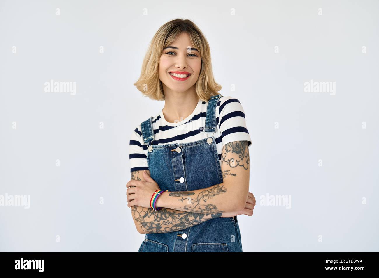 Happy gen z blonde young woman with tattoos standing isolated on white ...
