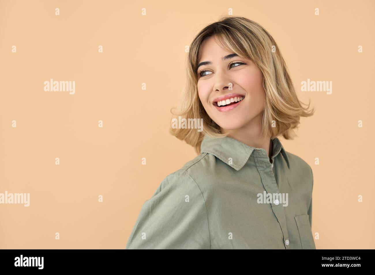 Happy gen z blonde student girl looking aside isolated on beige ...