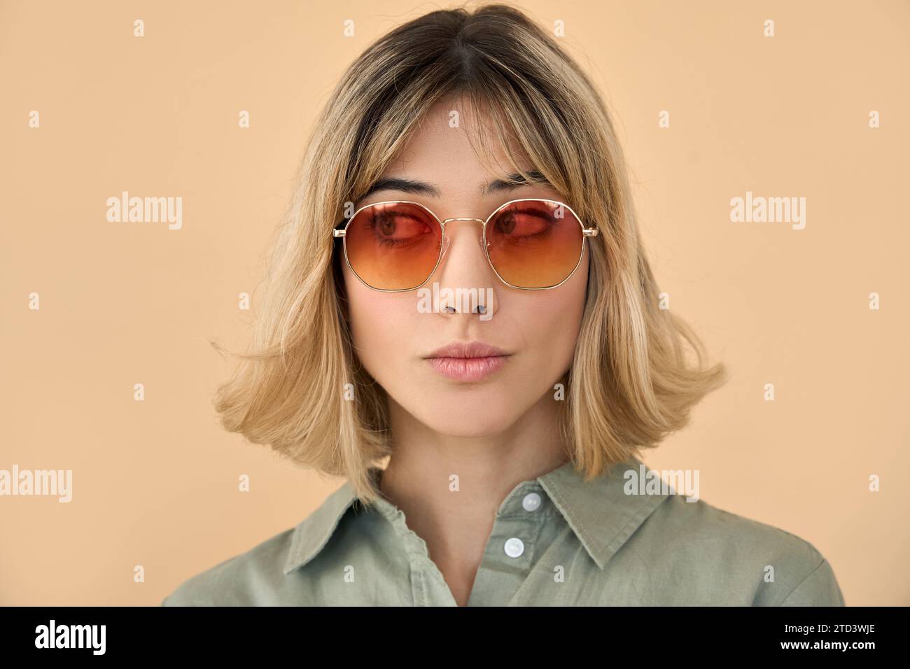 Gen z girl with short blond hair wearing sunglasses looking aside ...