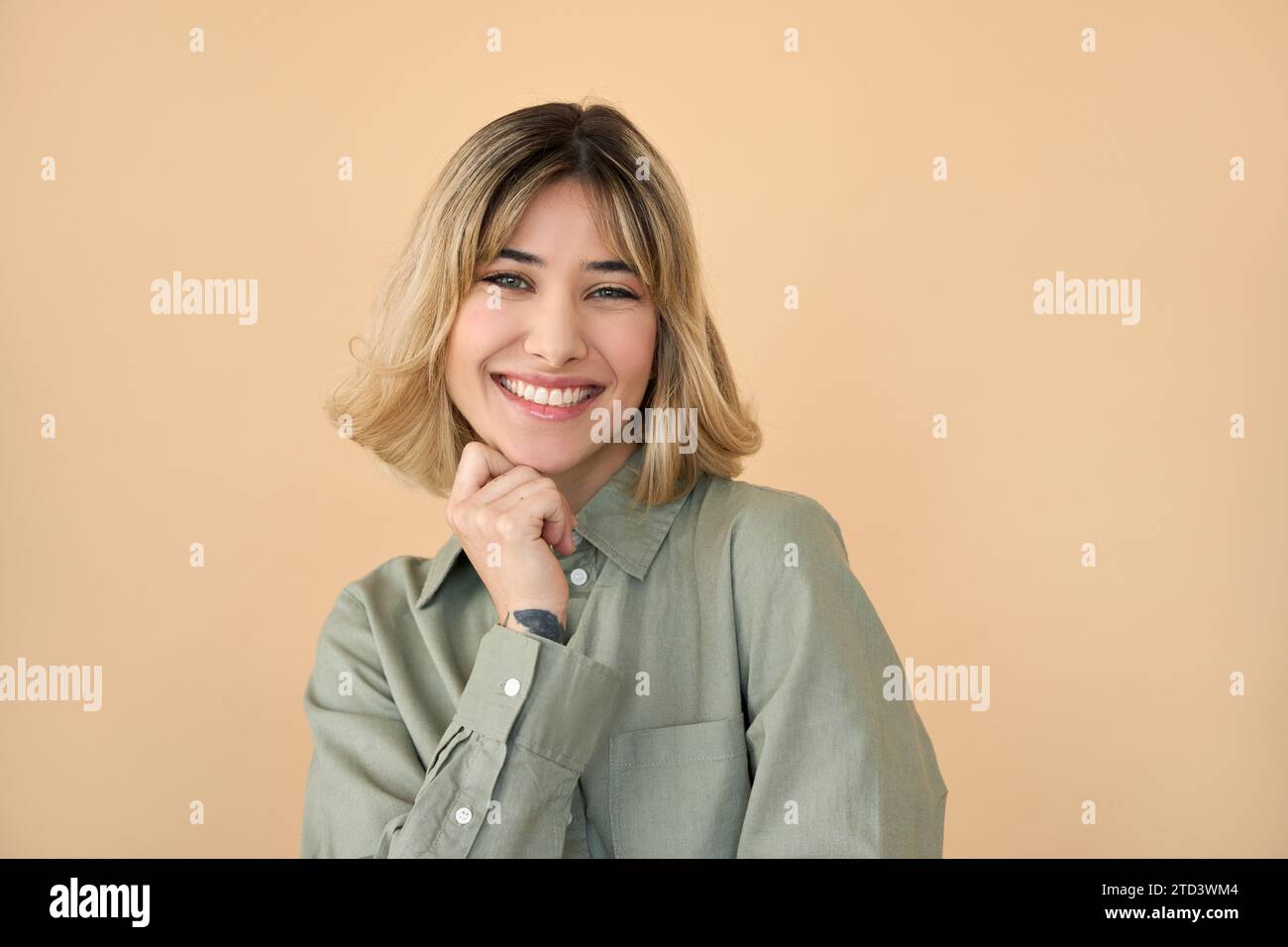 Happy gen z blonde student girl looking at camera isolated on beige ...