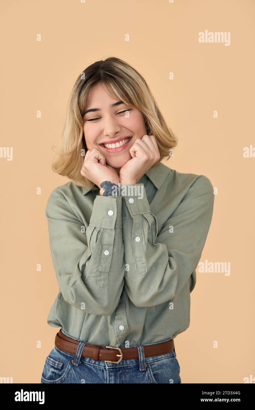 Cute gen z blonde young woman laughing standing isolated on beige ...