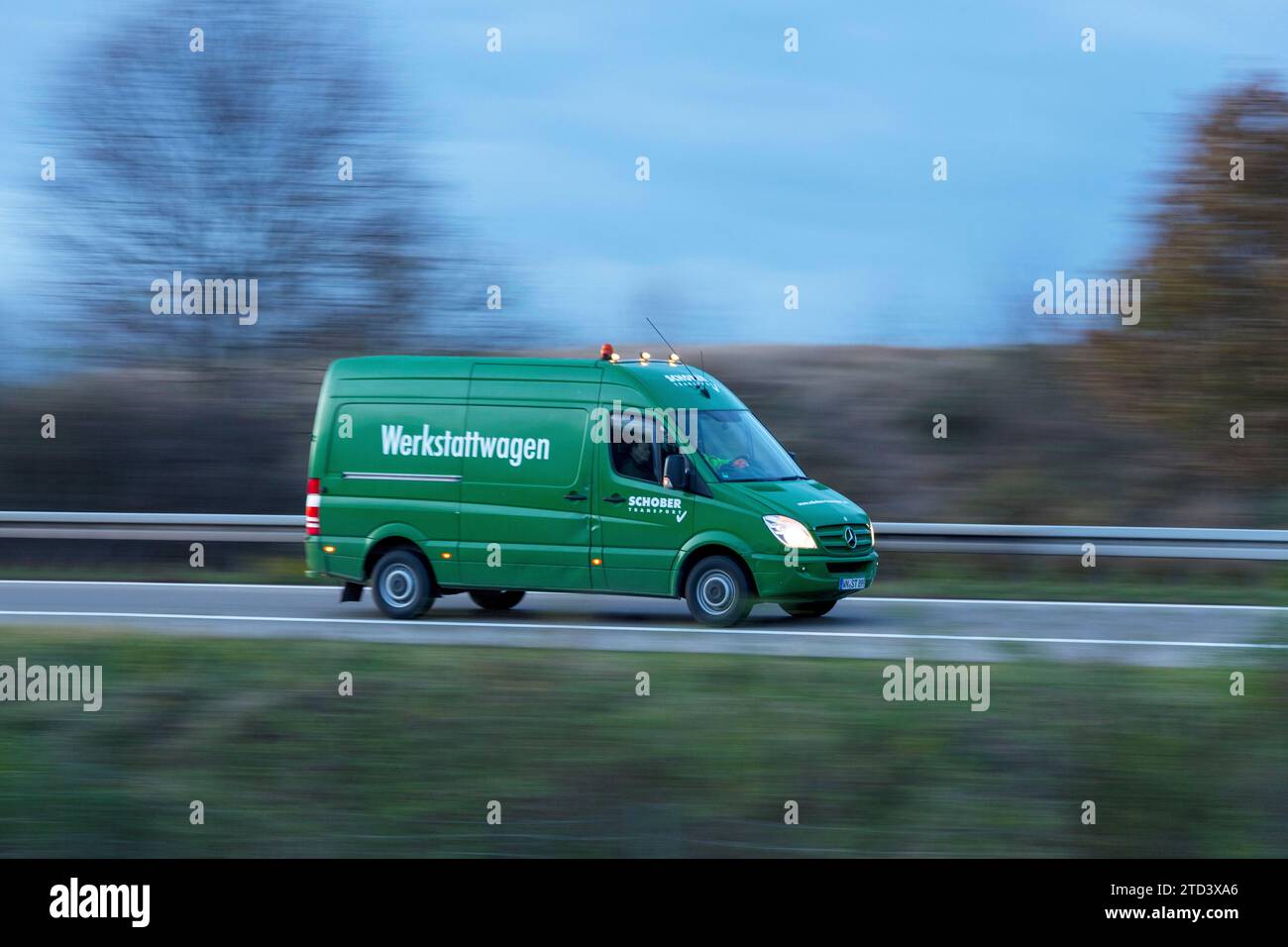 Green Mercedes van labelled Werkstattwagen driving on a country road ...