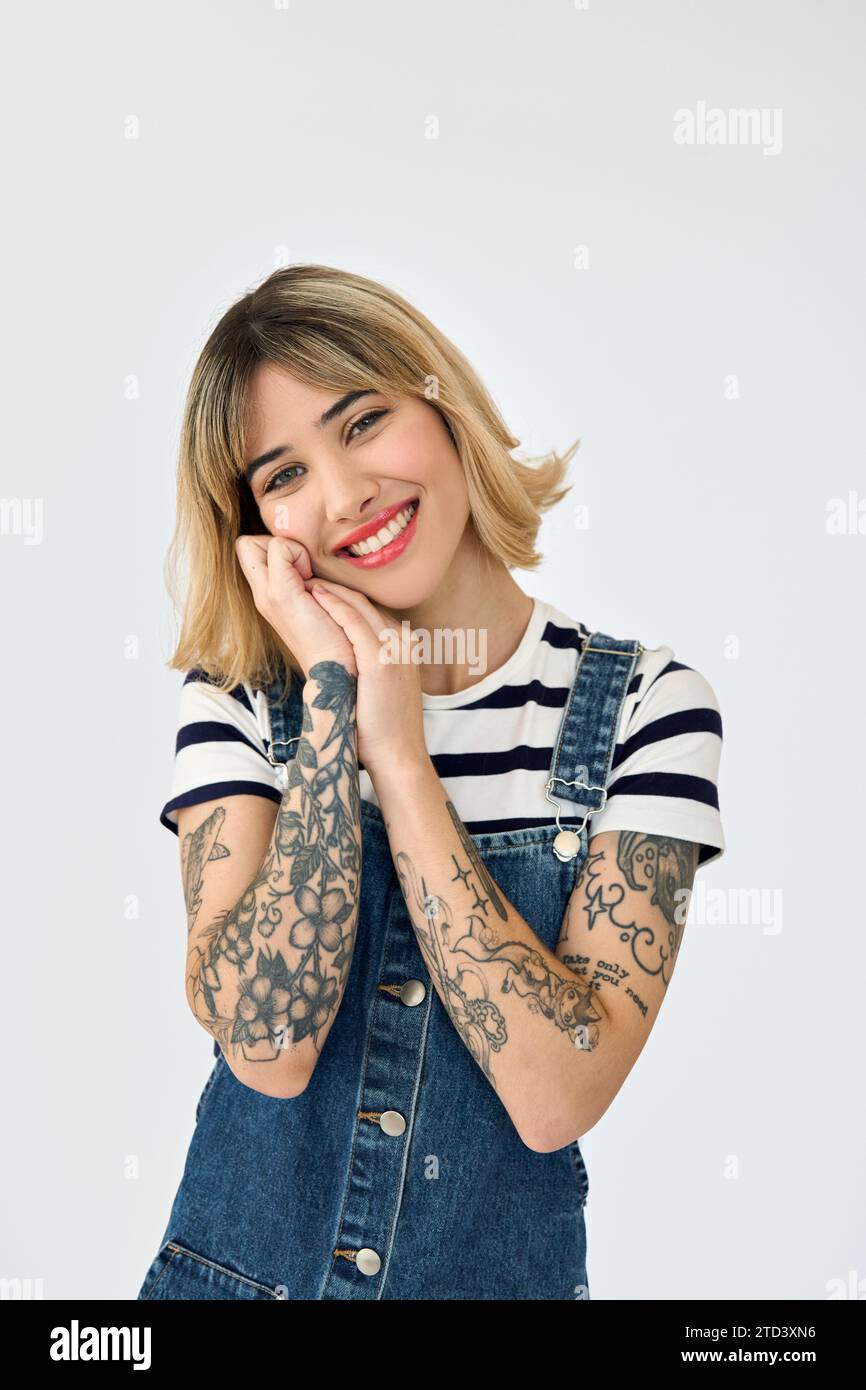 Happy gen z blonde stylish girl with tattoo standing isolated on white ...