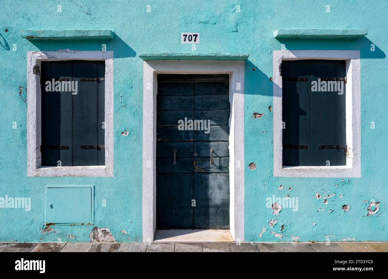 Light blue house facade with entrance door and windows with closed ...