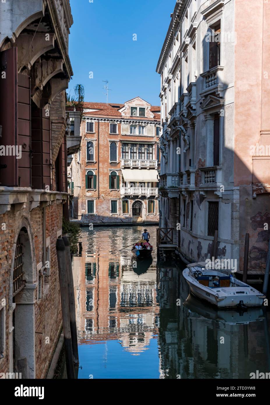Gondola travelling through a small canal, reflection, Venice, Italy Stock Photo - Alamy