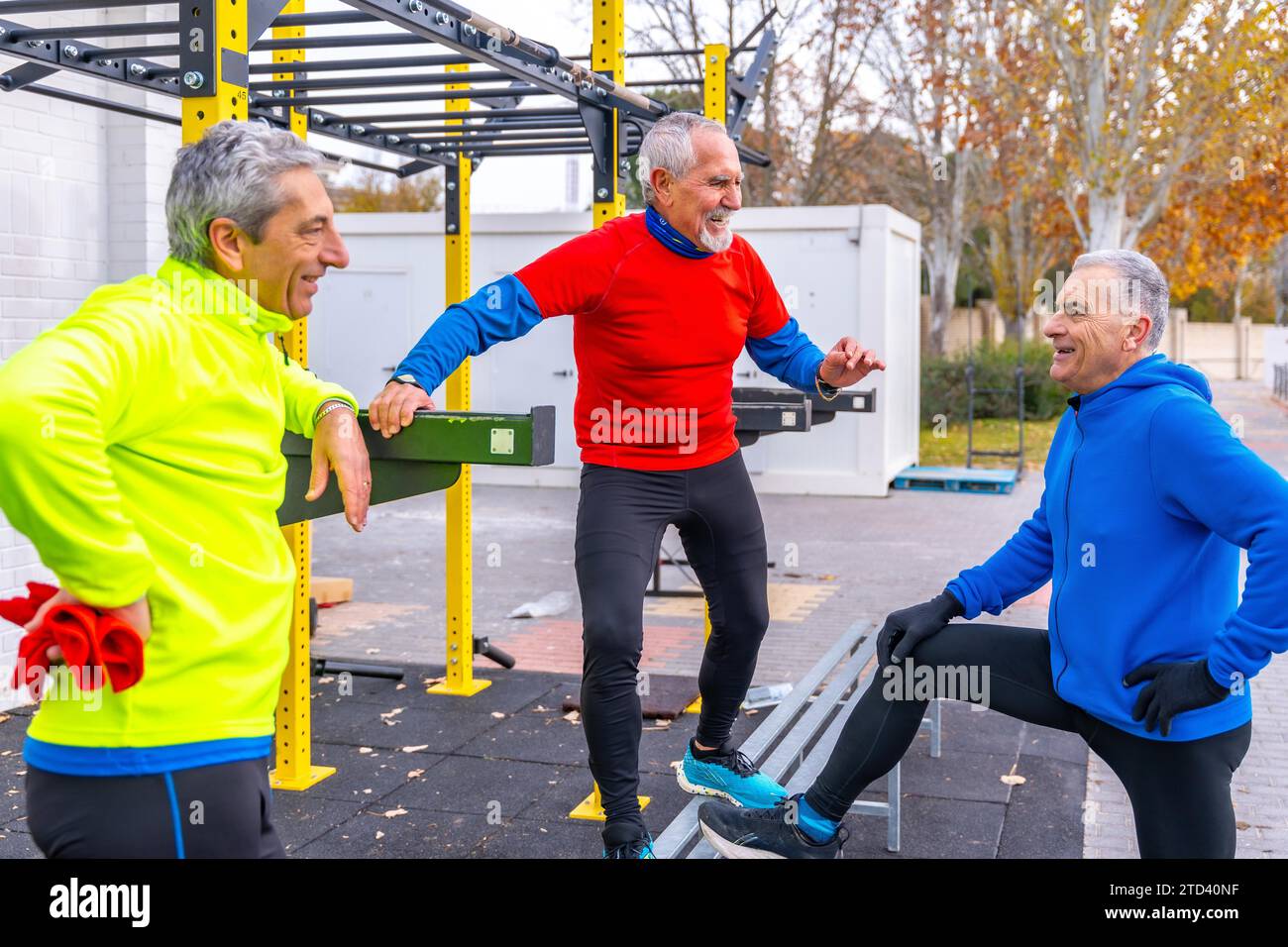 Three mature man chatting in a sports ground before to start training ...