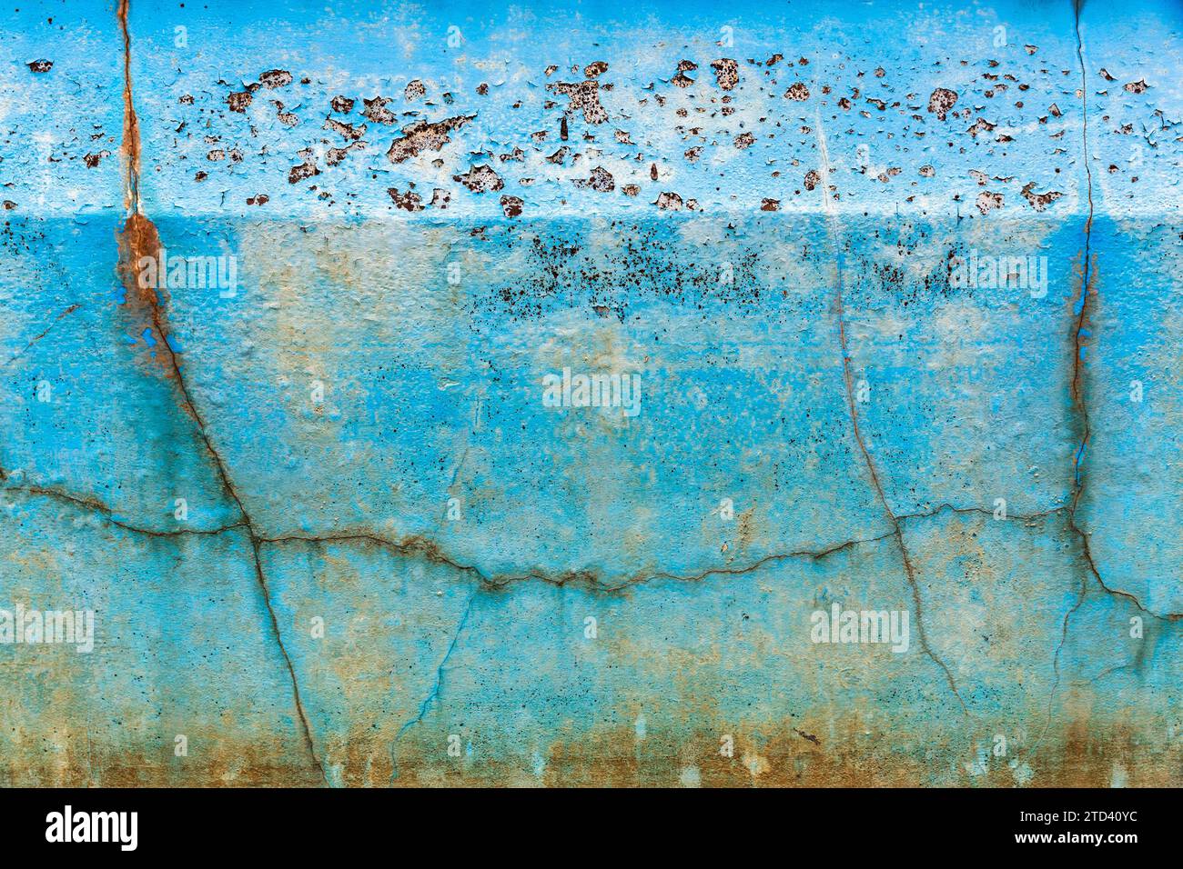 Dirty broken wall in a swimming pool, cracks, peeling blue colour ...