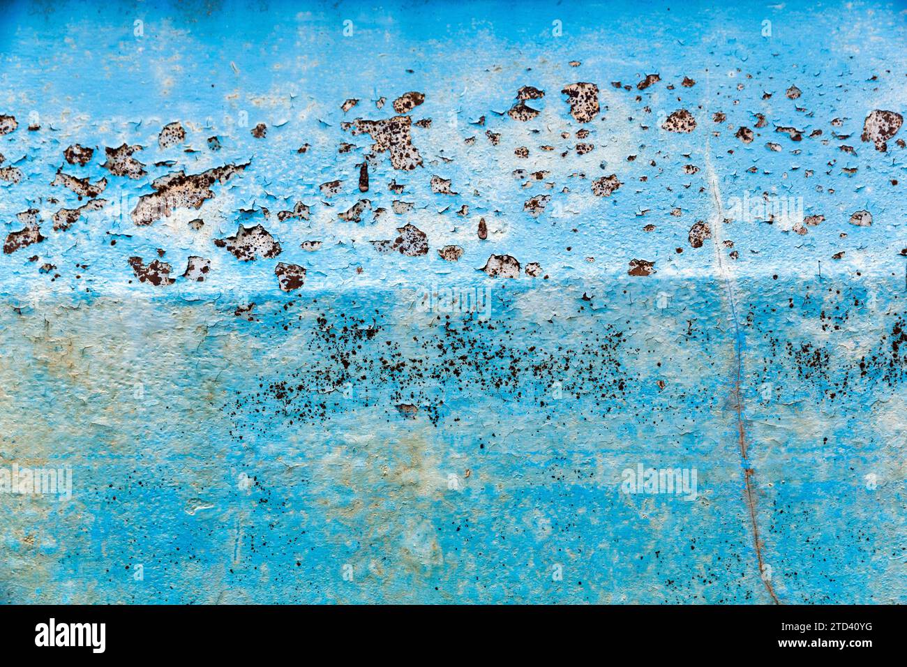 Dirty broken wall in a swimming pool, cracks, peeling blue colour ...