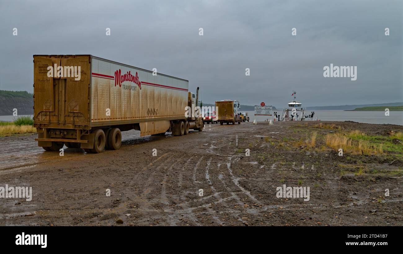 Waiting for the ferry at the Mackenzie River, dirty truck and several ...
