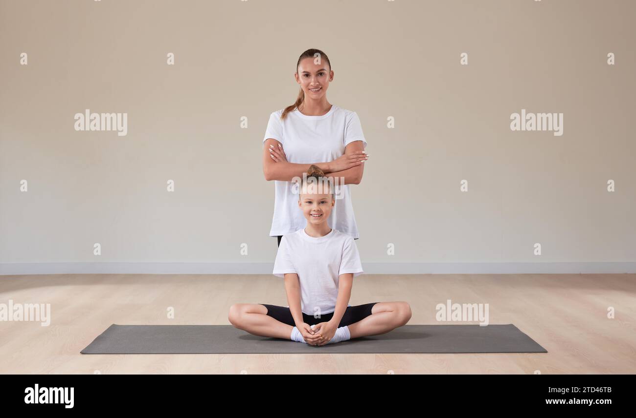 Beautiful female teacher poses with a little girl in a gymnastics class ...