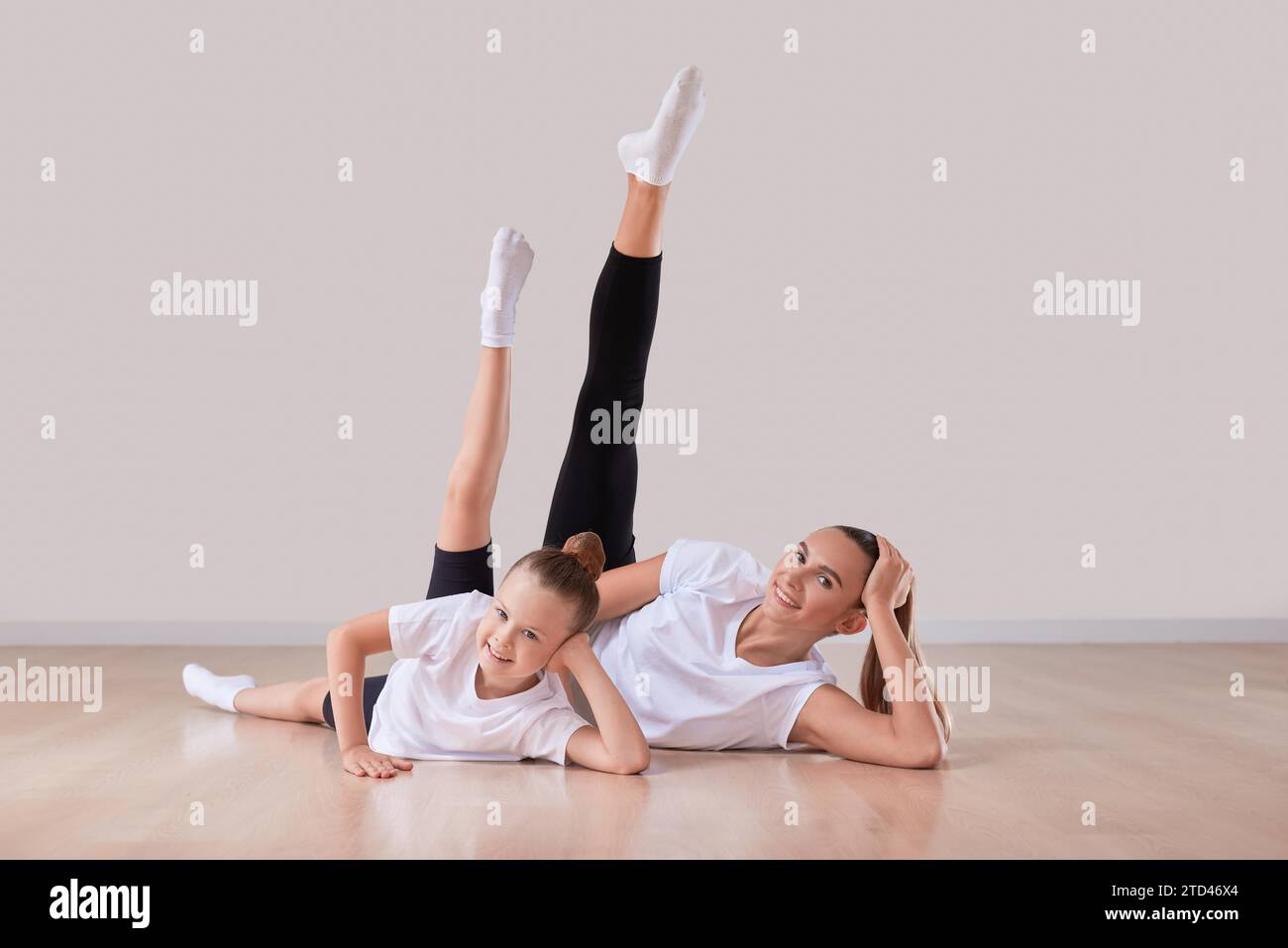 Beautiful female teacher poses with a little girl in a gymnastics class ...
