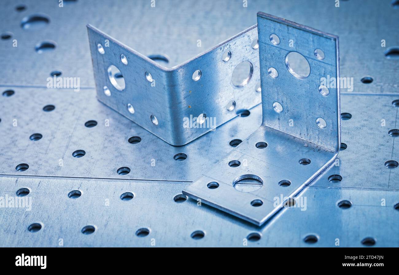 Stainless drilled angle iron on perforated metallic background ...