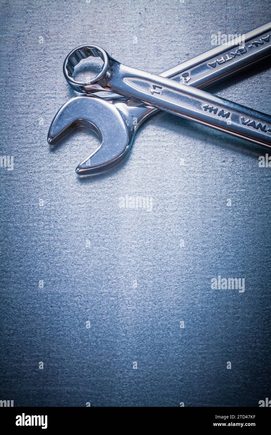 Stainless steel flat spanner and hook spanner on a metallic background ...