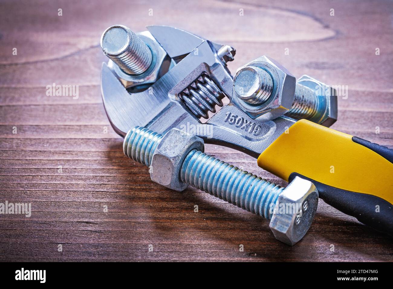 Adjustable spanner Steel threaded bolts and nuts on wooden plates ...