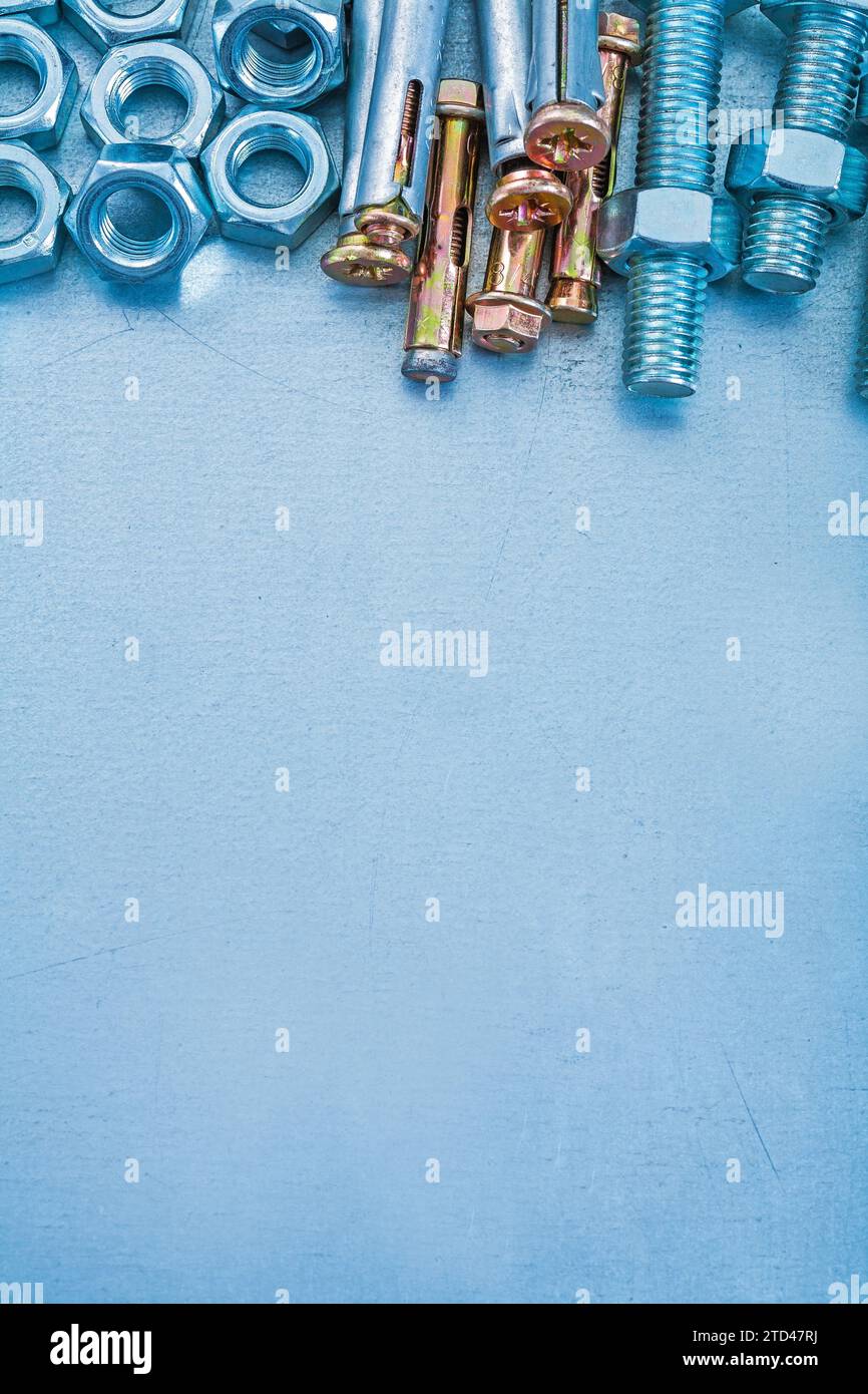 Metallic background with stainless steel anchor bolts, screws and nuts ...