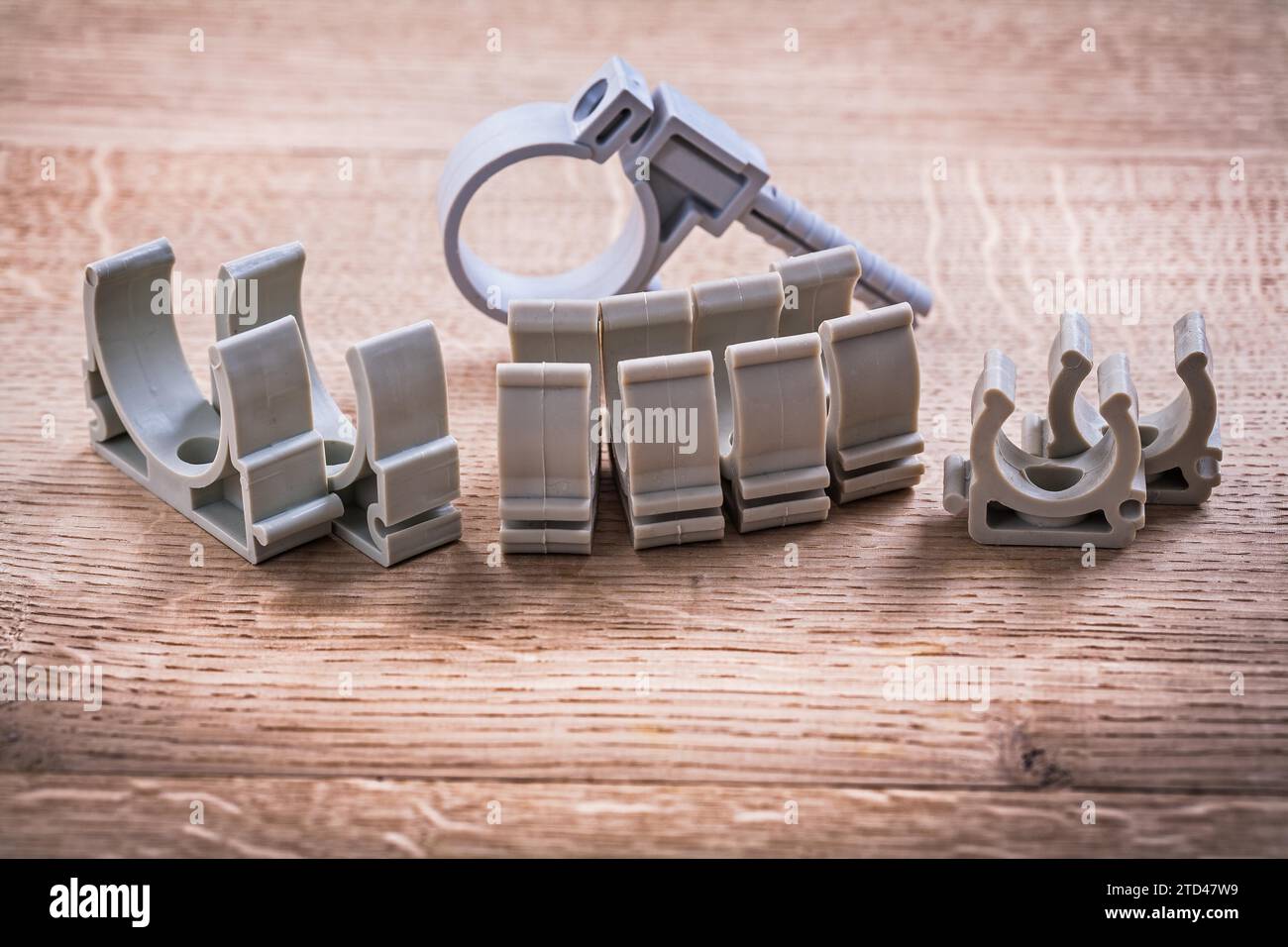 Set of plastic pipe fasteners on wooden board Stock Photo - Alamy