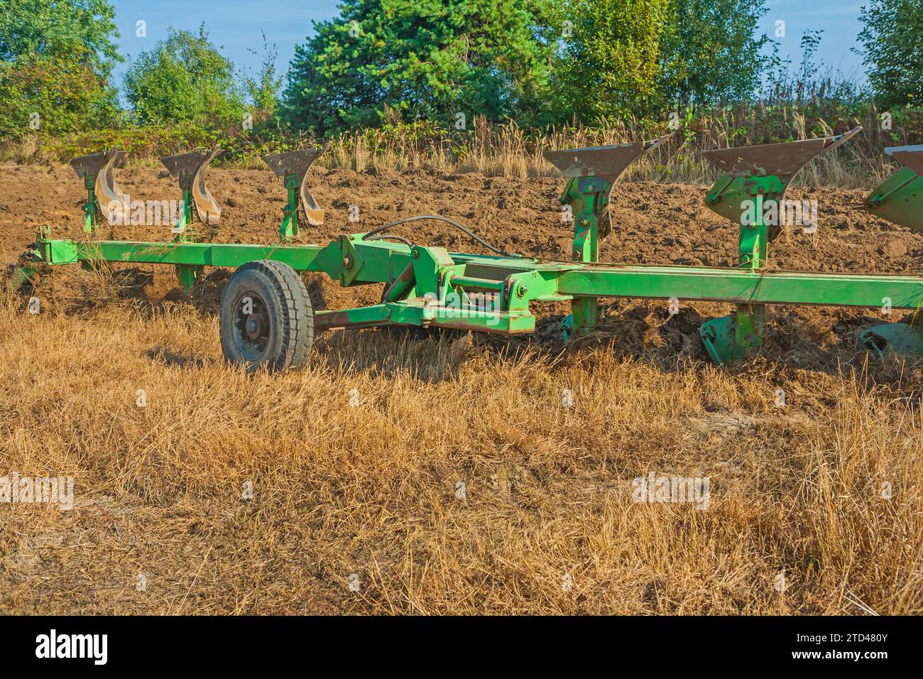 Large set of plough on field in work agricultural concept Stock Photo ...