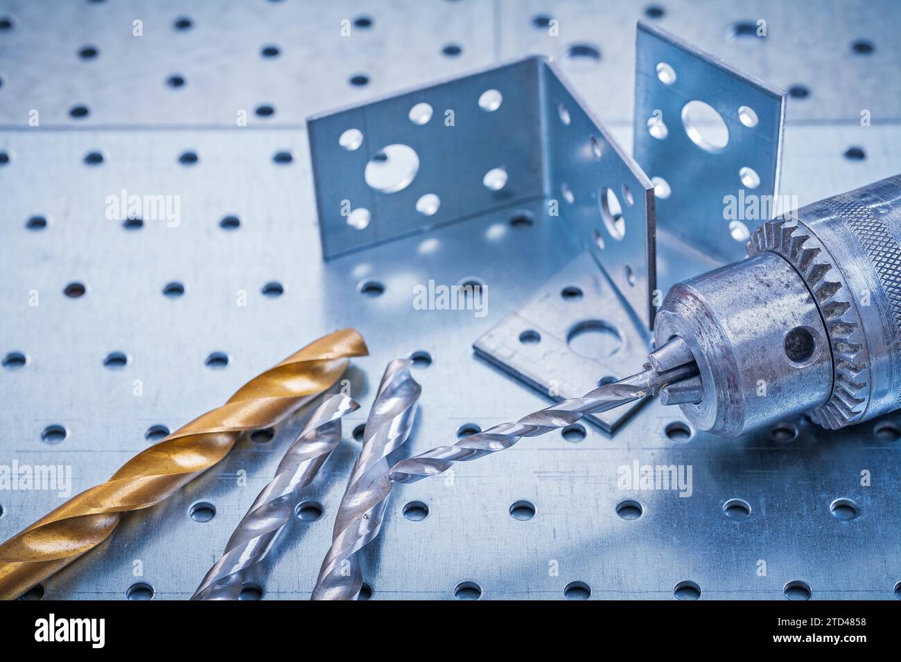 Drill with metal drills and drilled angle bars on a perforated metal ...
