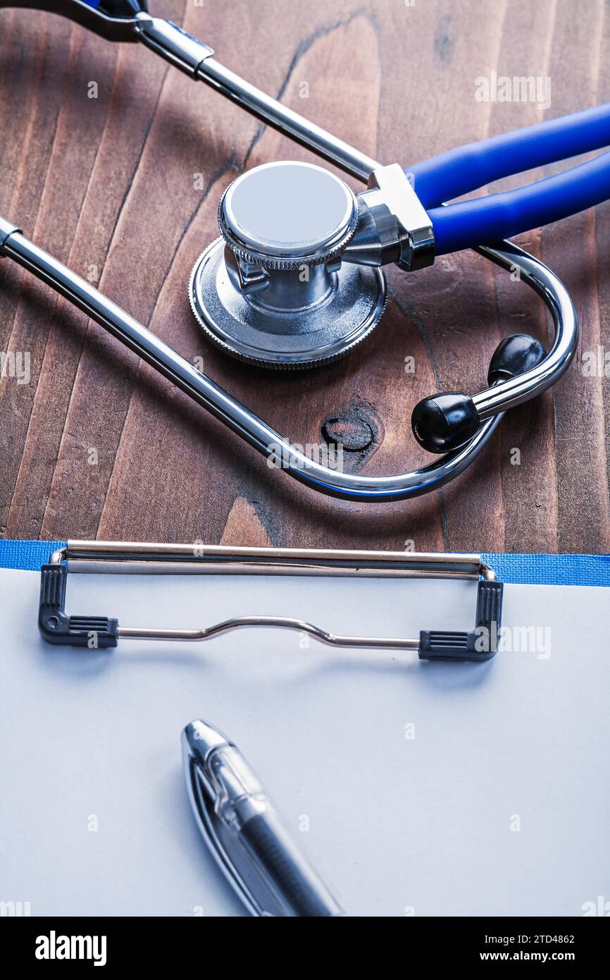 Clipboard with paper sheet and biros Stethoscope on vintage wooden ...