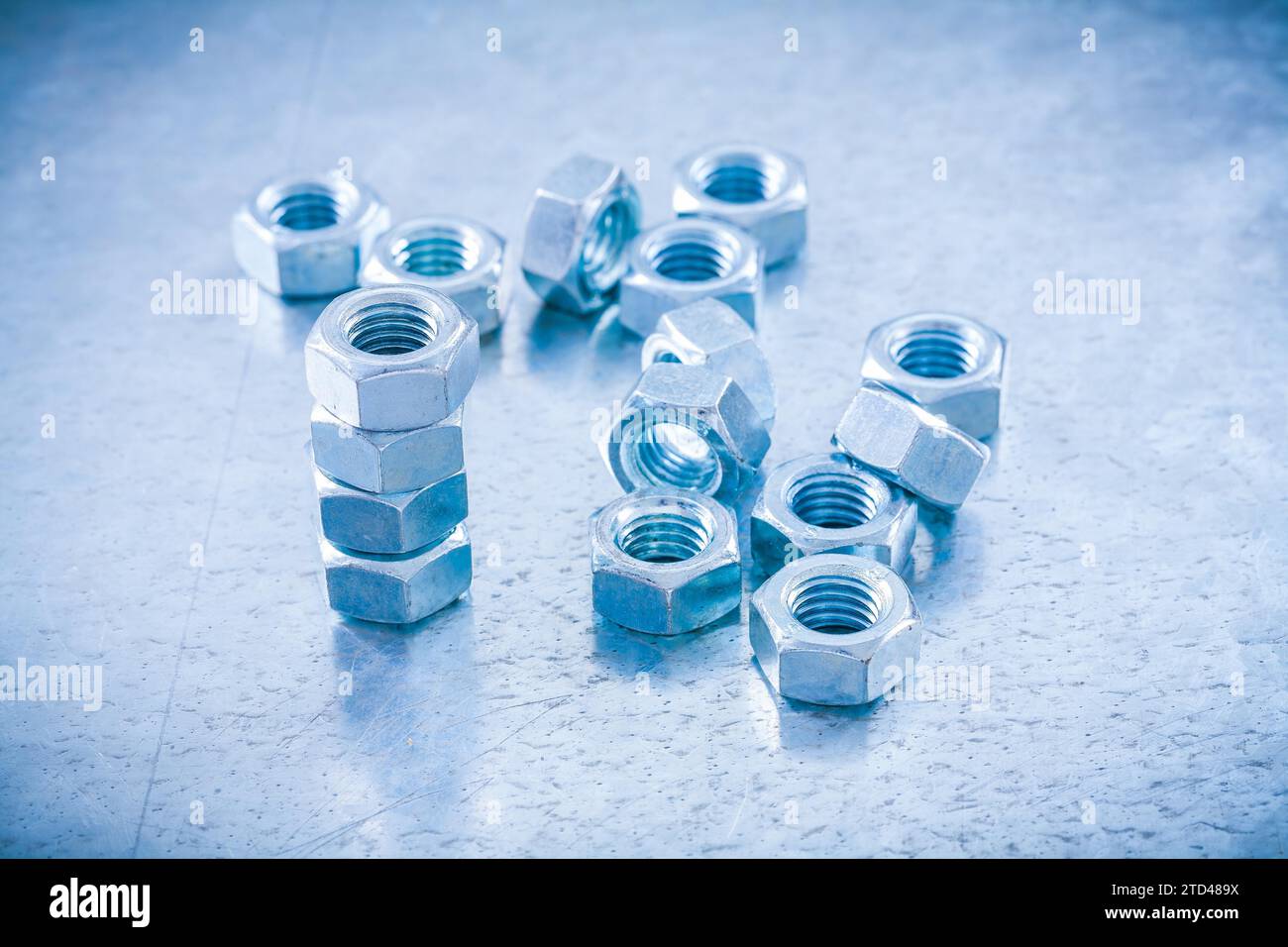 Metal threaded nuts on a metallic background Construction concept Stock ...