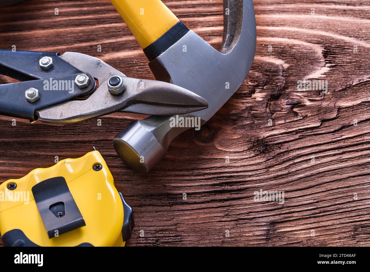 Metal claw hammer pliers and adhesive tape line on wooden board ...