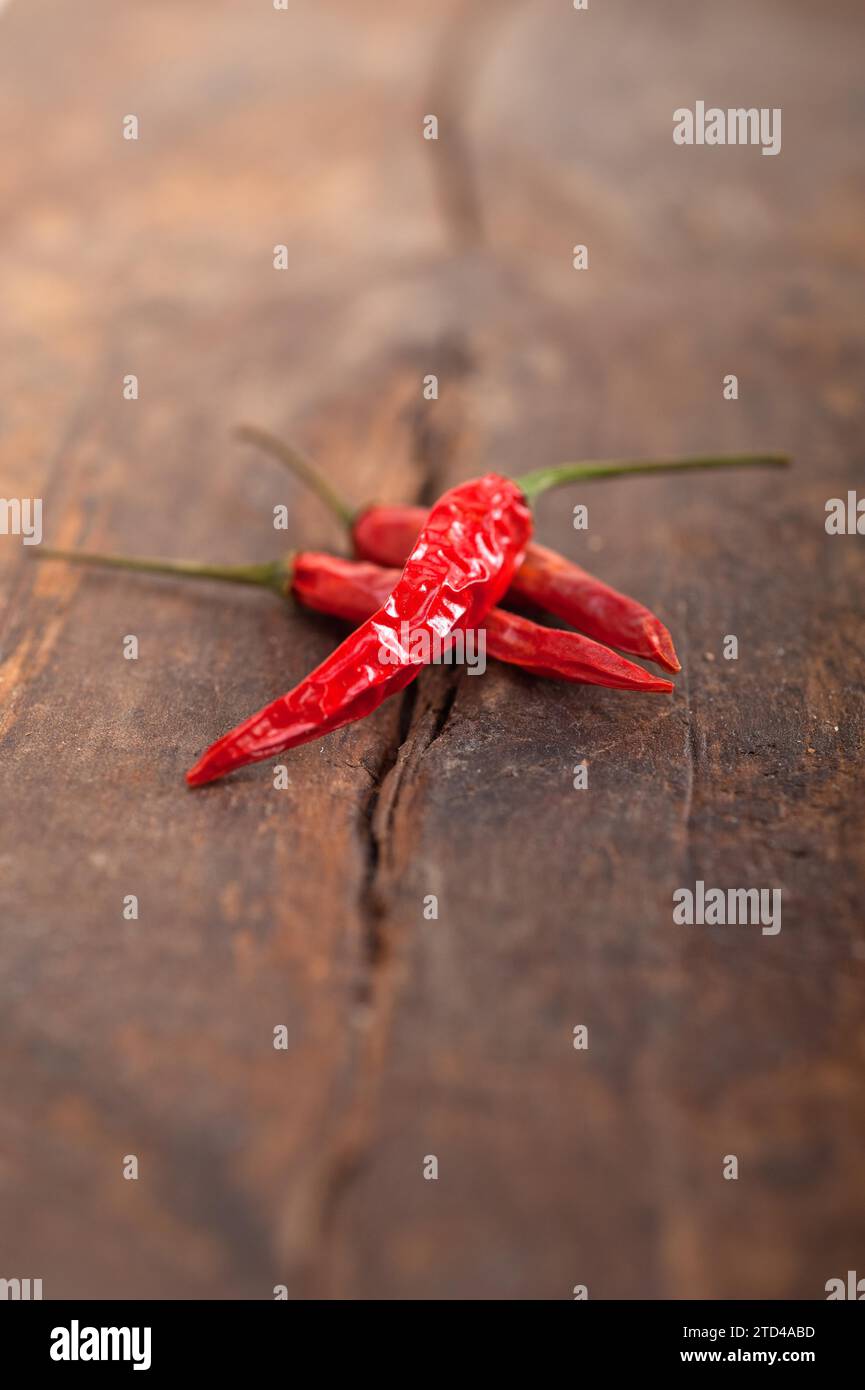 Dry red chili peppers over old wood table Stock Photo - Alamy