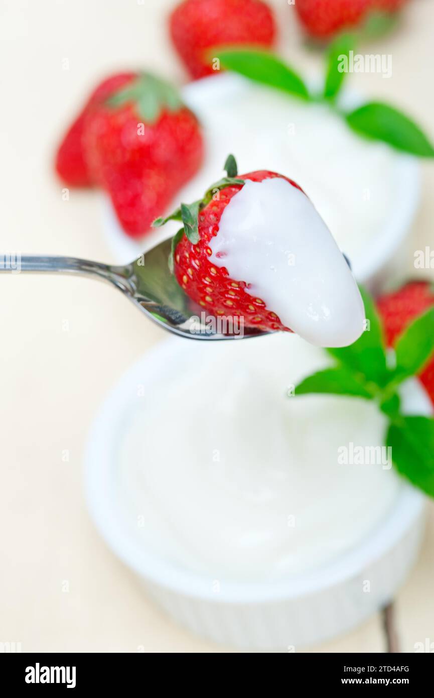 Organic Greek yogurt and strawberry over white rustic wood table Stock ...