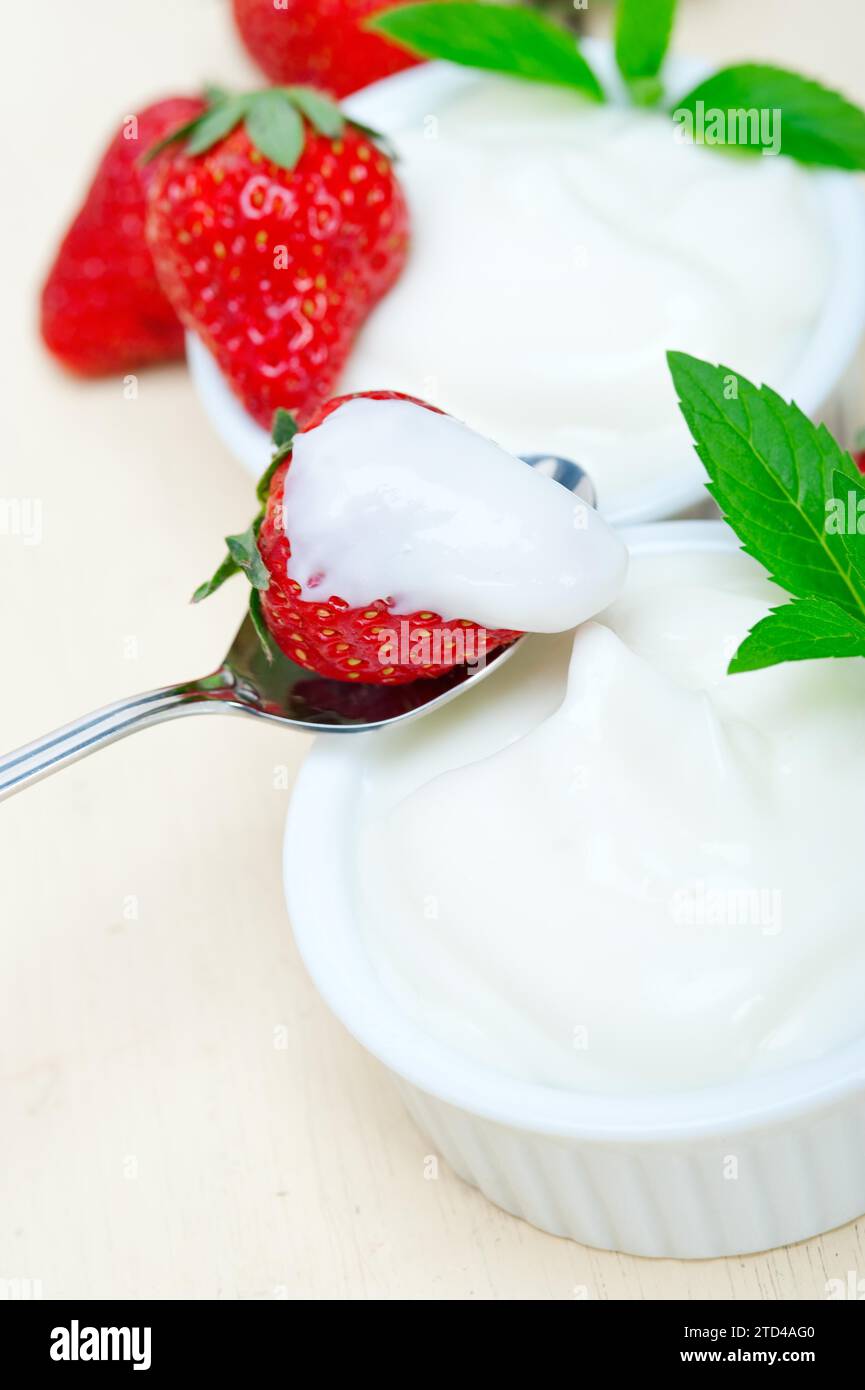 Organic Greek yogurt and strawberry over white rustic wood table Stock ...