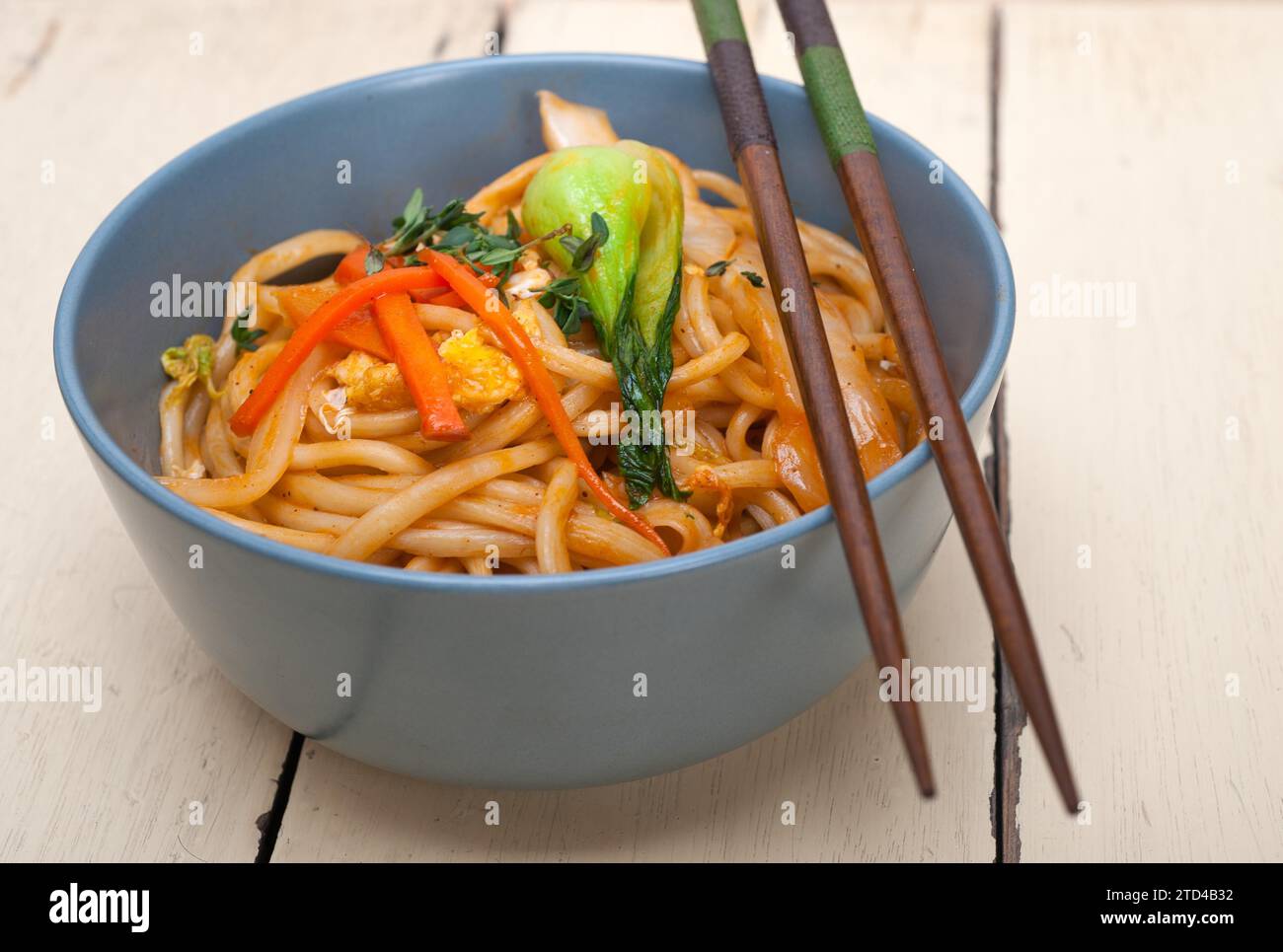 Hand pulled stretched Chinese ramen noodles on a bowl with chopstick ...