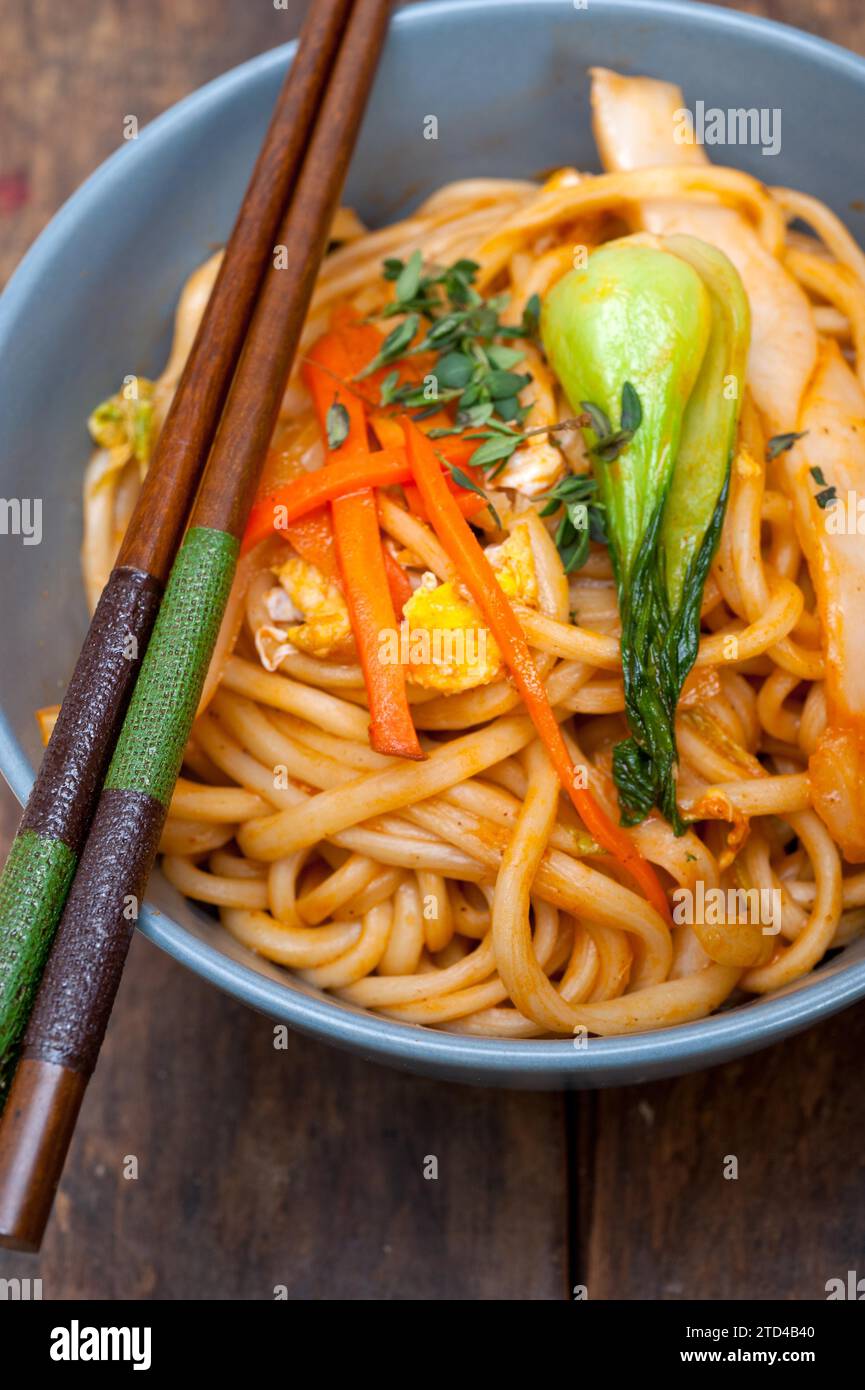 Hand pulled stretched Chinese ramen noodles on a bowl with chopstick ...