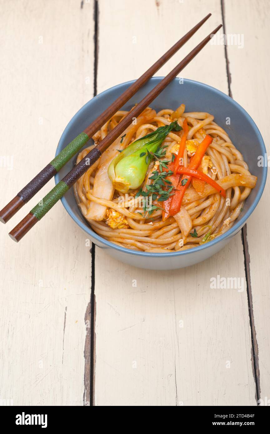 Hand pulled stretched Chinese ramen noodles on a bowl with chopstick ...