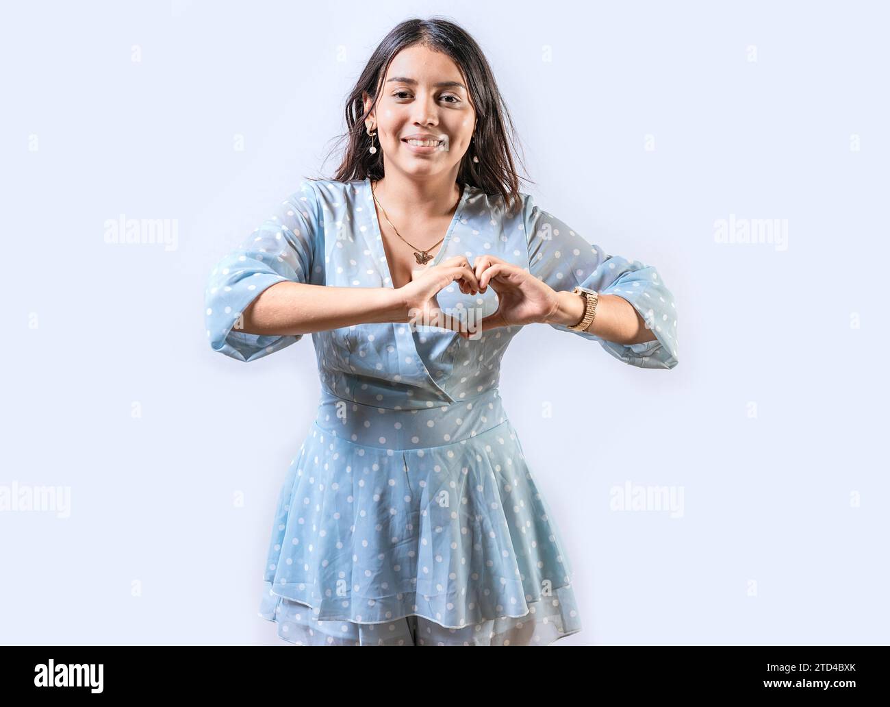 Funny young girl making heart shape with hands. Teen girl making heart ...