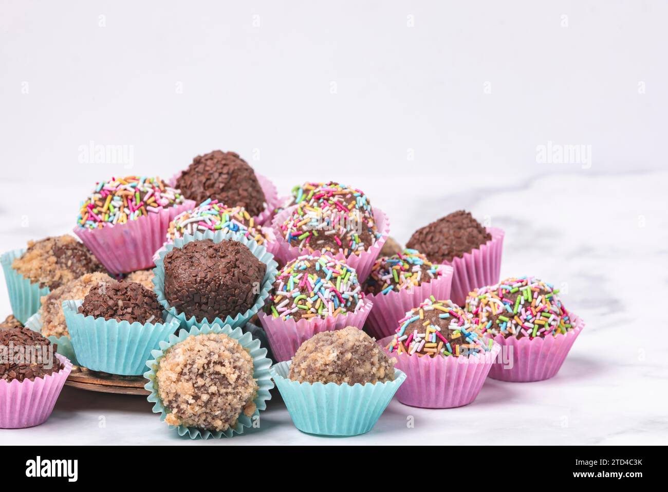 Dark rum balls with nut, chocolate and colourful sprinkles in pink and ...