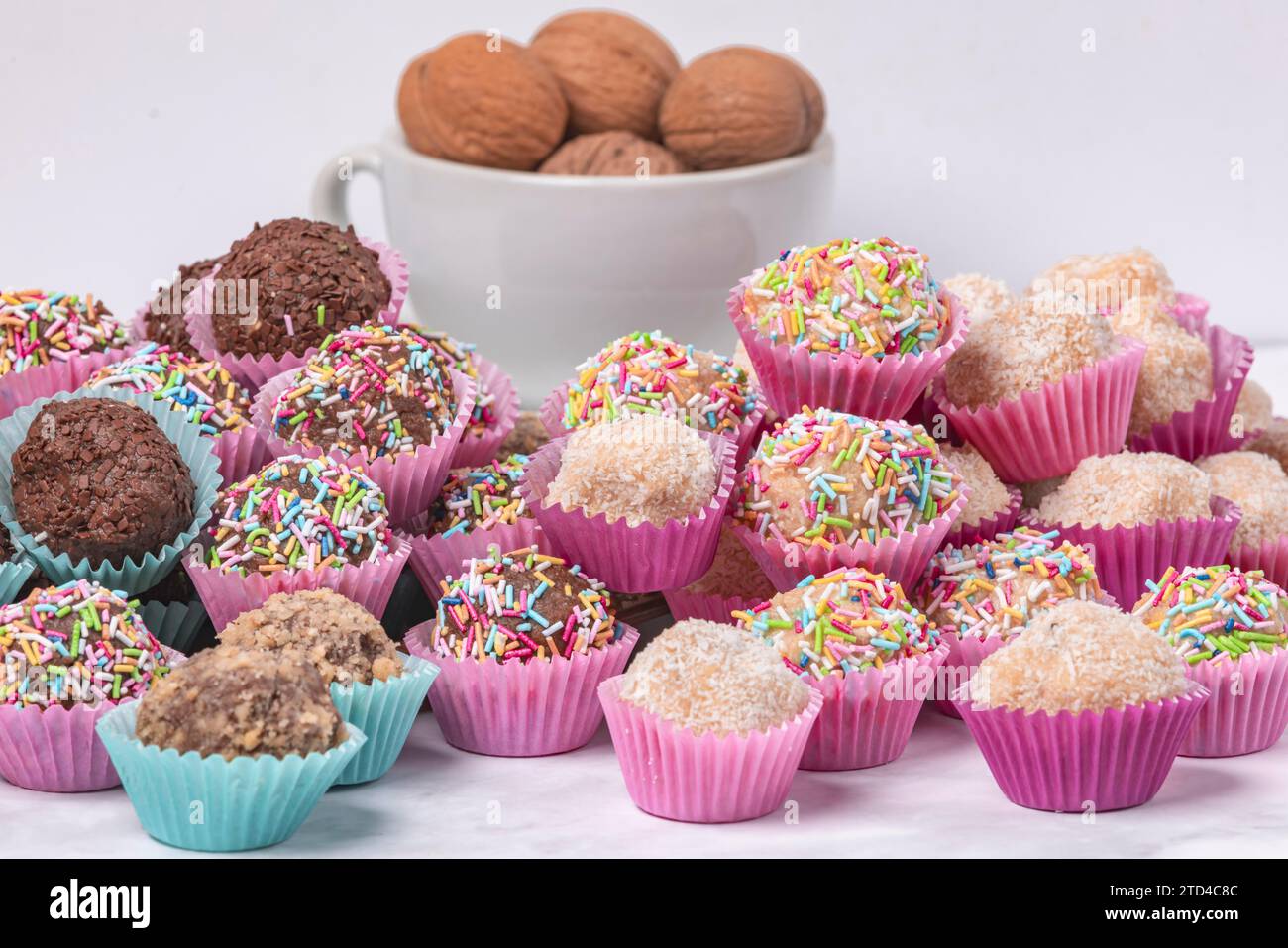 A selection of handmade light and dark rum balls on a white background ...
