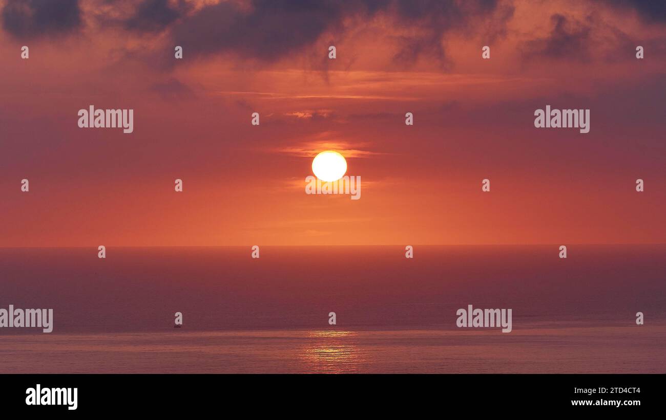 Sunset, Orange sun ball, grey clouds, orange-red evening sky, volcanic ...