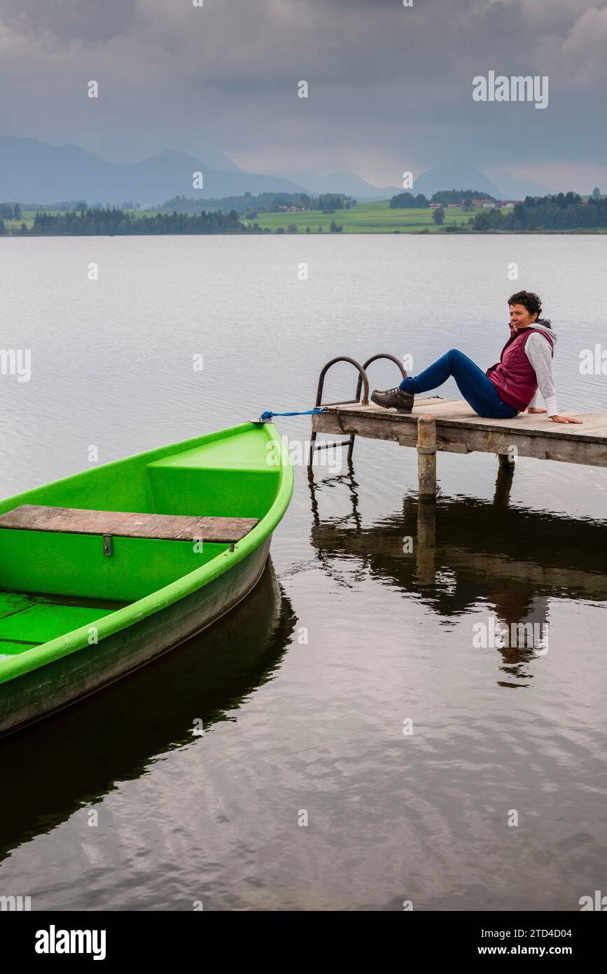 Woman, wooden jetty, green rowing boat, Hopfensee, Hopfen am See, near ...