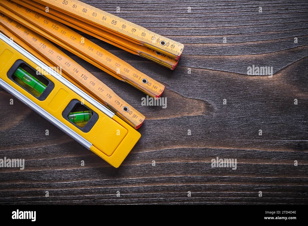 Horizontal view of yellow construction level with wooden metre on ...