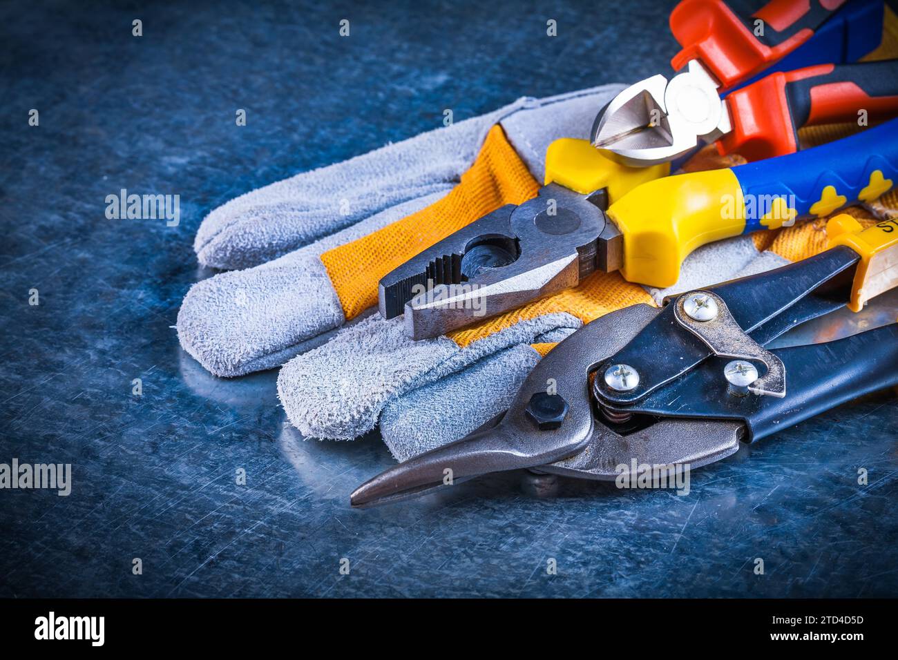 Safety gloves with pliers pliers and tin snips on scratched vintage ...