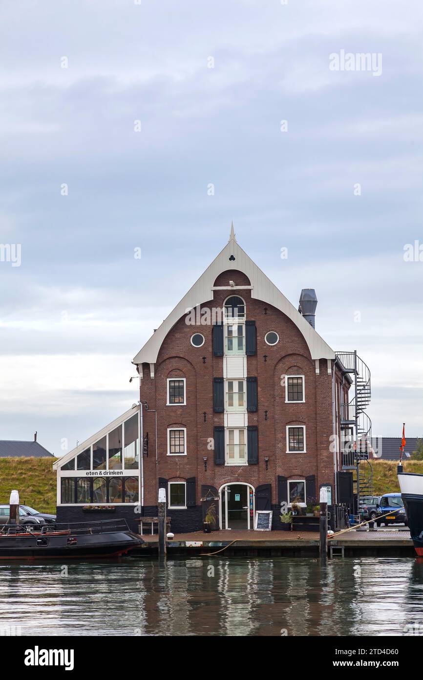 Historic warehouse, now a fish restaurant, harbour of Oudeschild, Texel ...