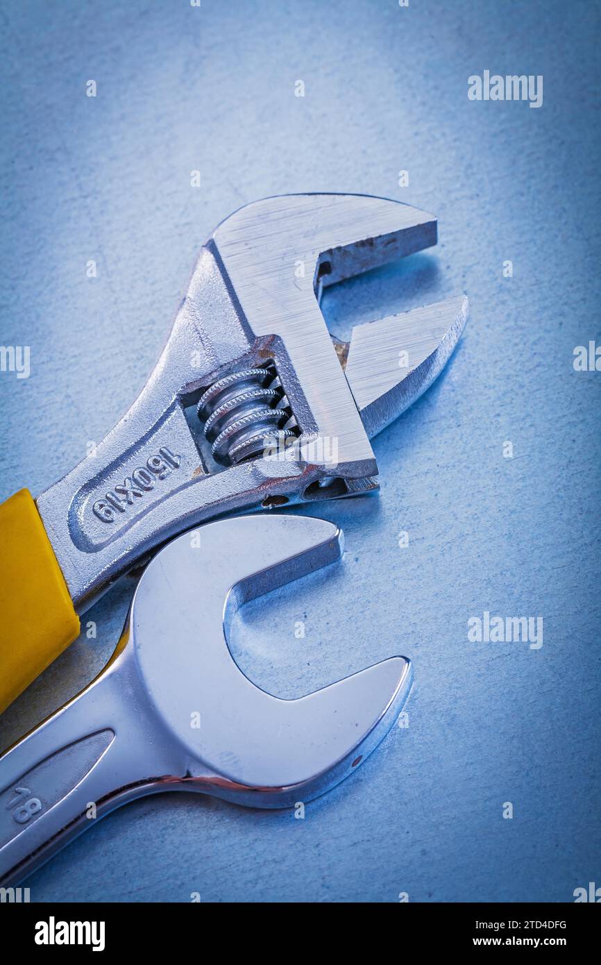 Metallic background with stainless steel adjustable spanner and hook ...