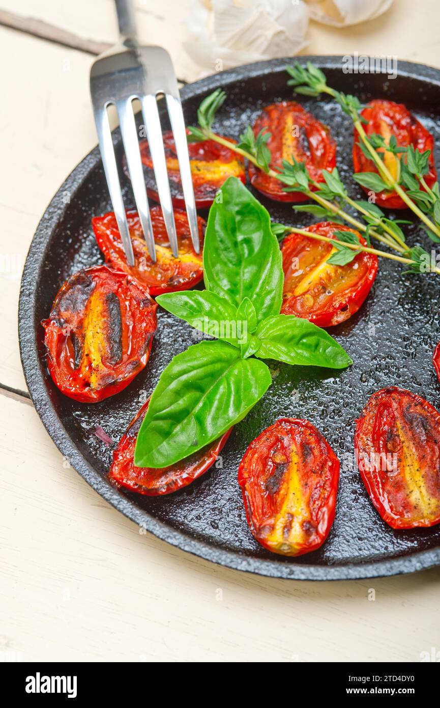 Oven baked cherry tomatoes with basil and thyme on a cast iron skillet ...