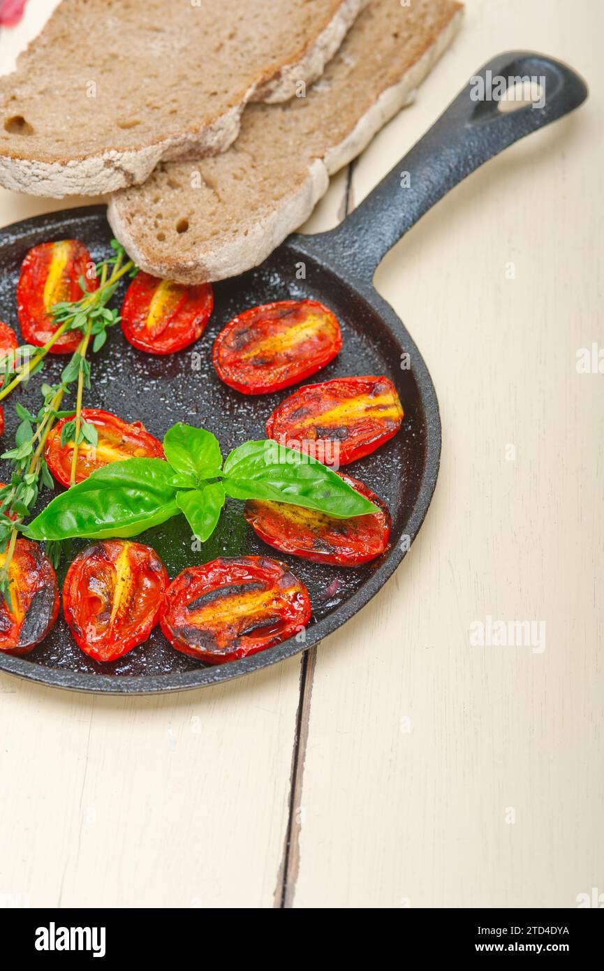 Oven baked cherry tomatoes with basil and thyme on a cast iron skillet ...