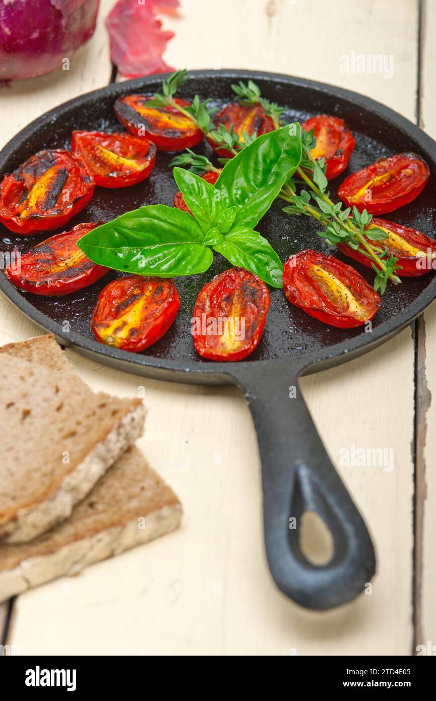 Oven baked cherry tomatoes with basil and thyme on a cast iron skillet ...
