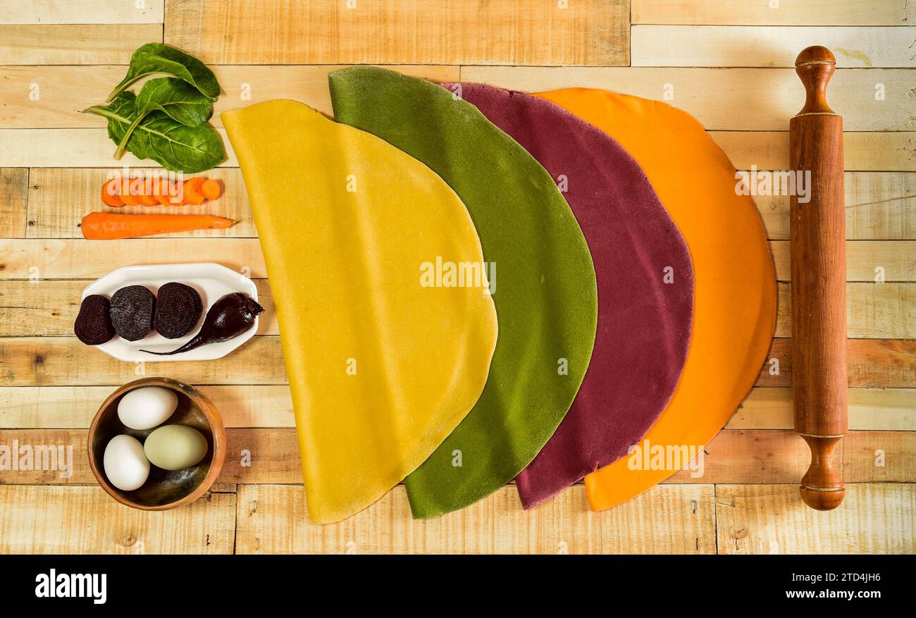 Colored dough for noodles stretched on the table, Italian cuisine made ...