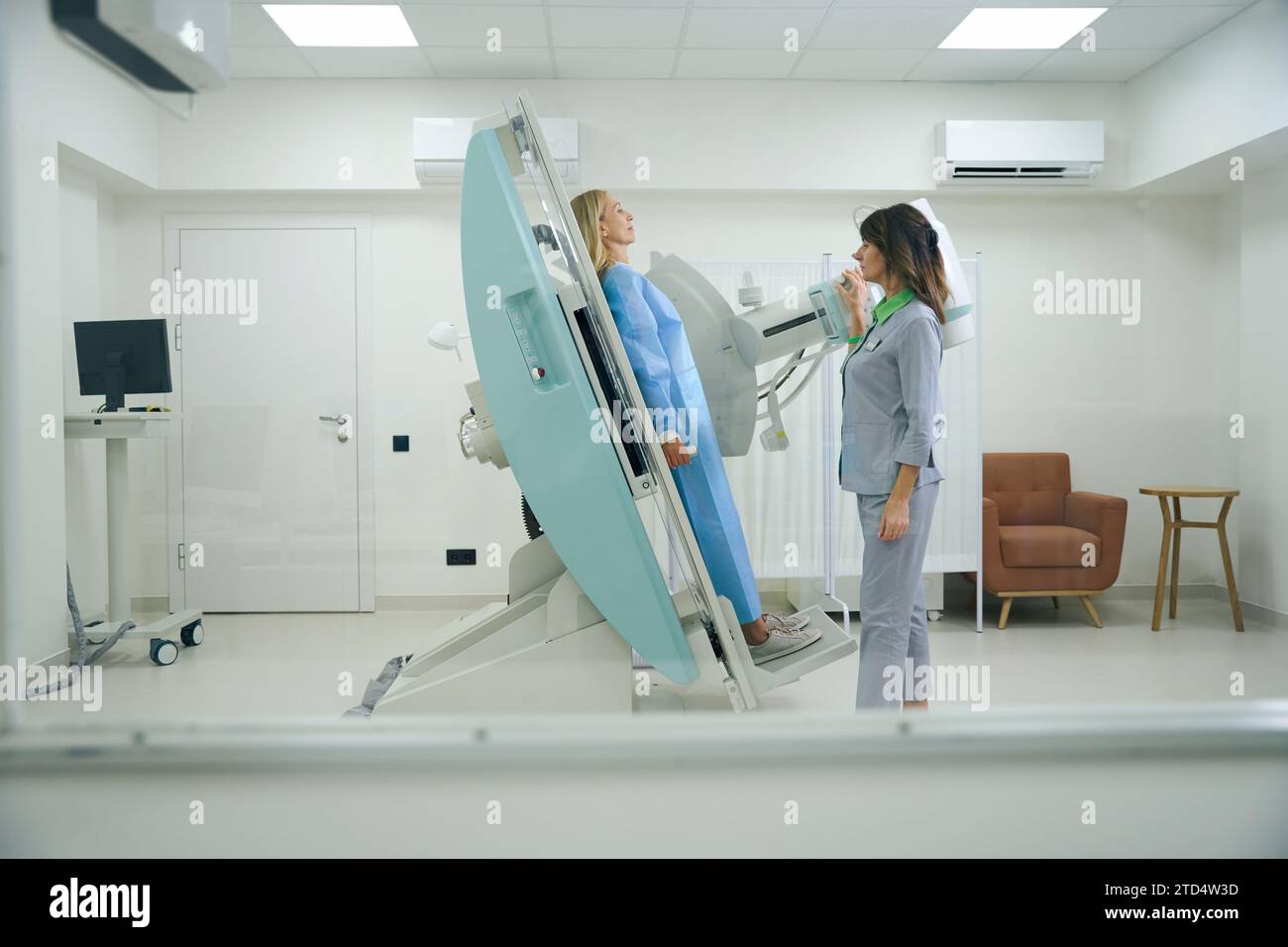 Experienced radiologic technologist preparing adult female for ...