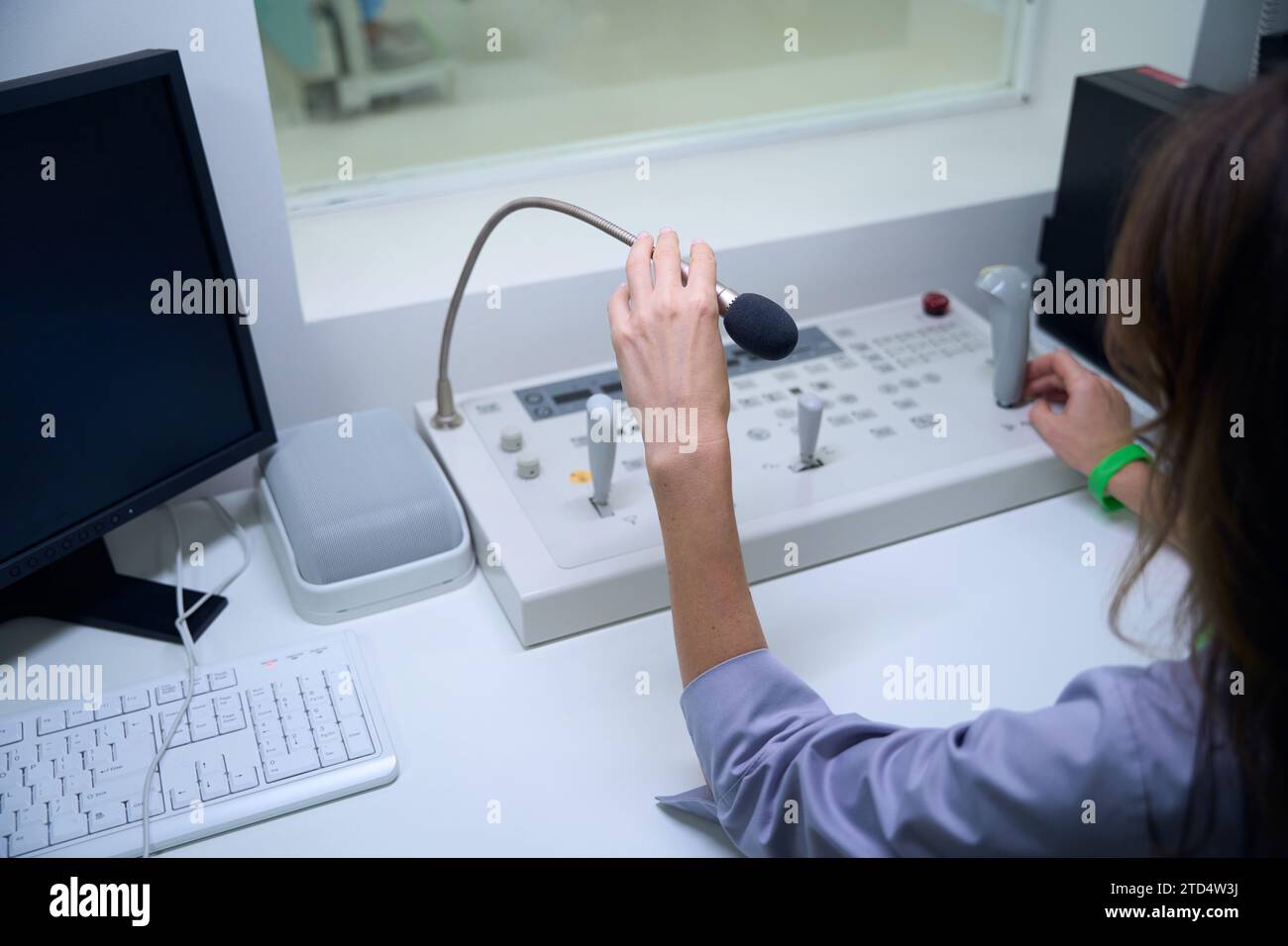 Clinical radiographer operating radiographic equipment from control ...